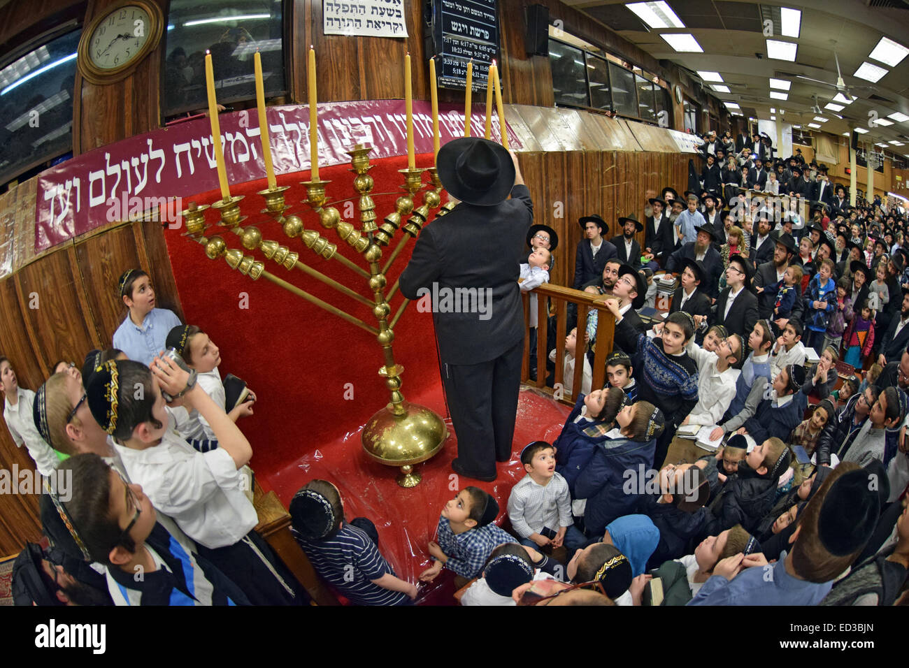 An orthodox Jewish rabbi lights Hanukkah candles as students and ...