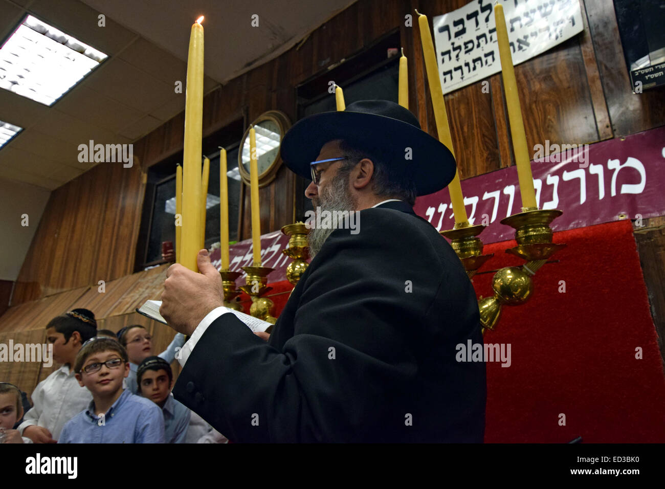 An orthodox Jewish rabbi recites the blessings before lightin Hanukkah ...