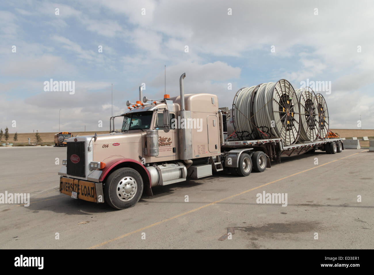 An American Peterbilt 379 semi truck hauling reels of HDPE plastic pipe ...