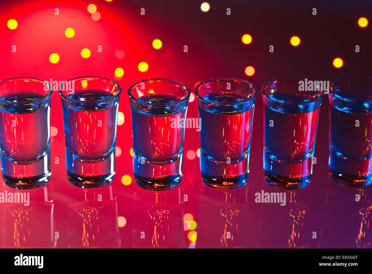Glasses with an alcoholic drink on a glass table Stock Photo - Alamy