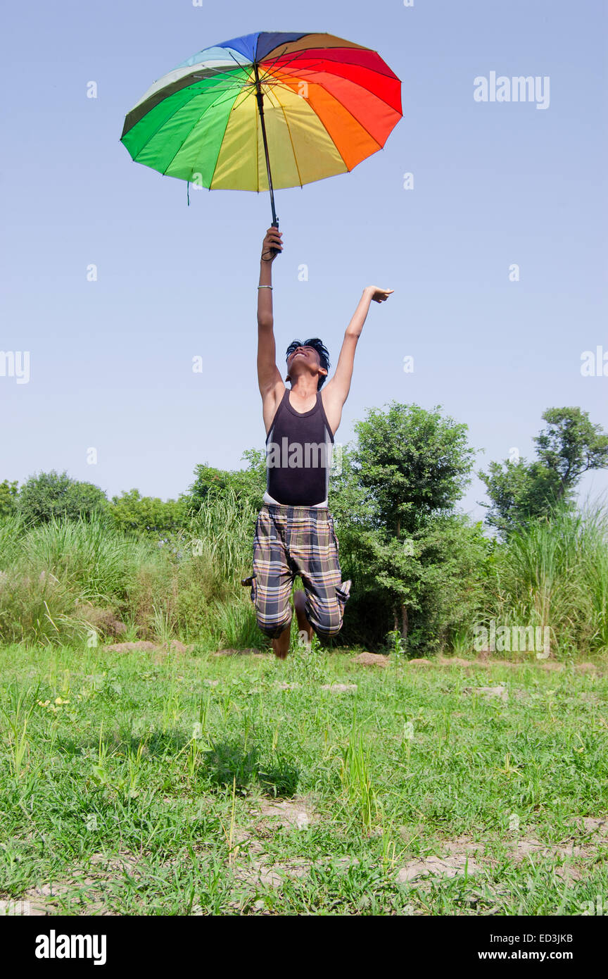 1 rural boy farm Jumping holding Umbrella rain season enjoy Stock Photo ...