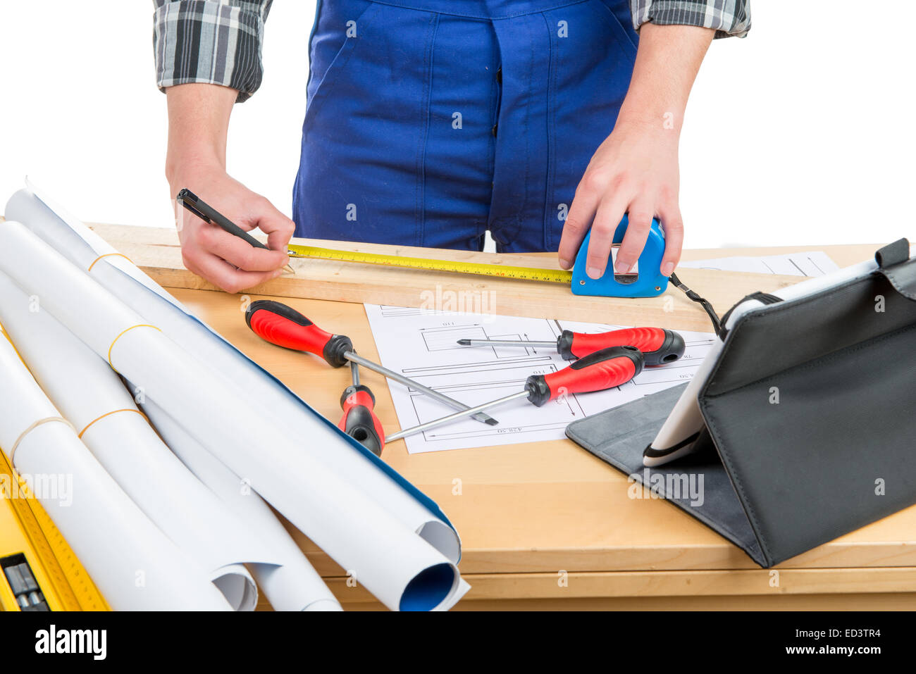 a worker measuring a board with a tape measure Stock Photo - Alamy