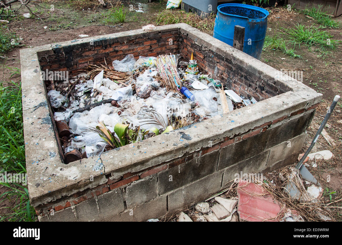 Garbage dump in the cement box behind the urban village Stock Photo - Alamy