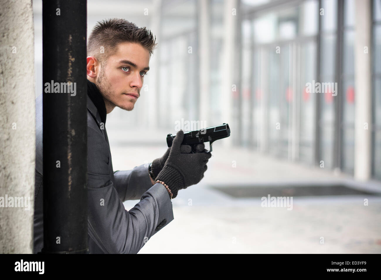 Well dressed handsome young detective or policeman or mobster standing ...