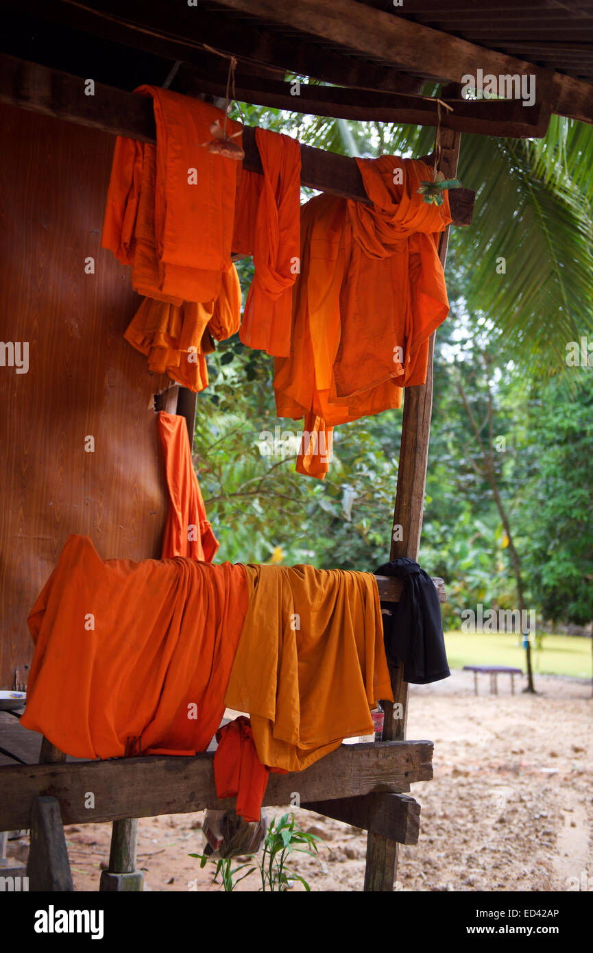 Orange and saffron robes of Buddhist monks hanging on wooden temple ...