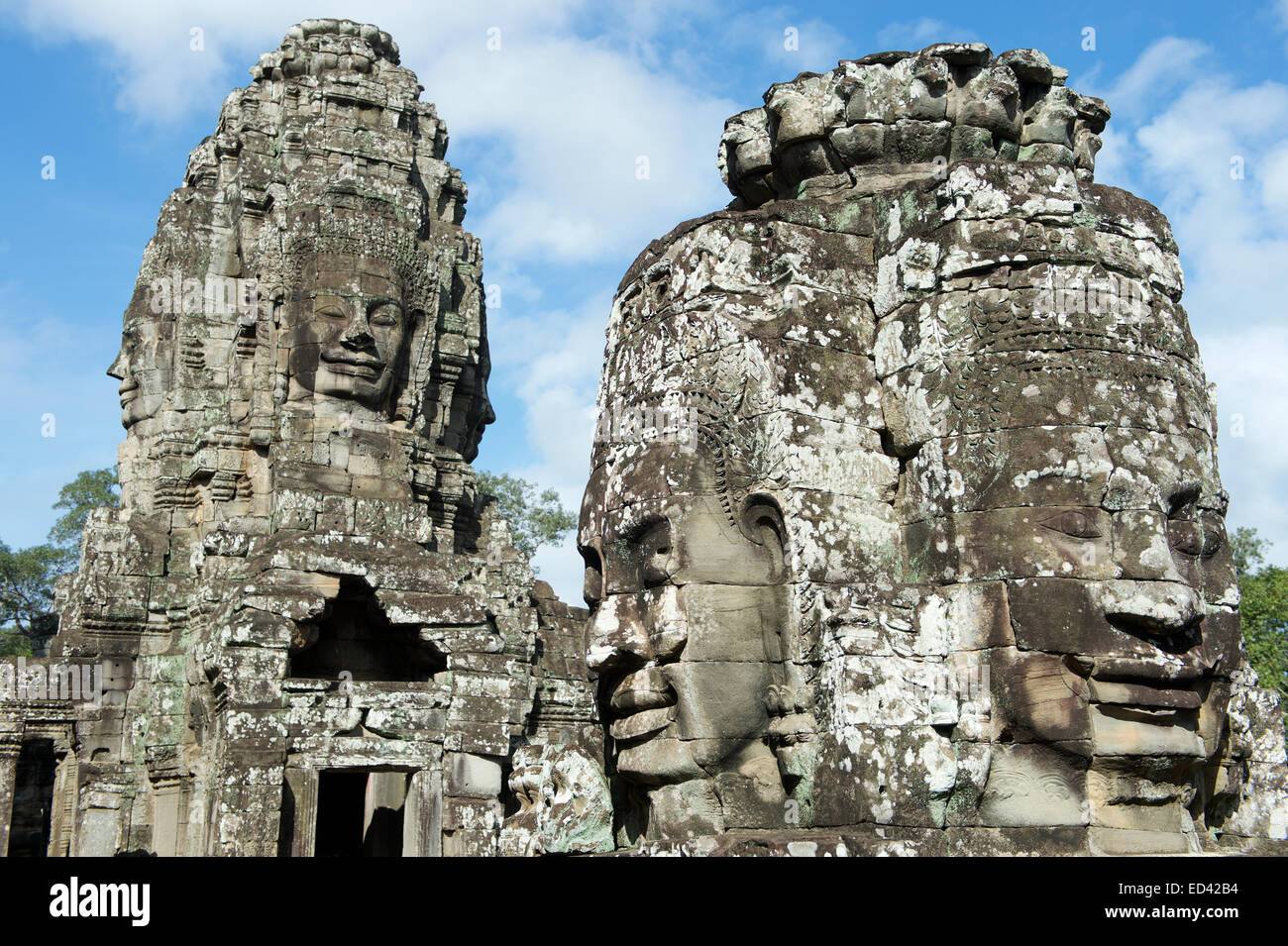 Angkor Wat Temple of Bayon stone face sculpture green trees blue sky ...