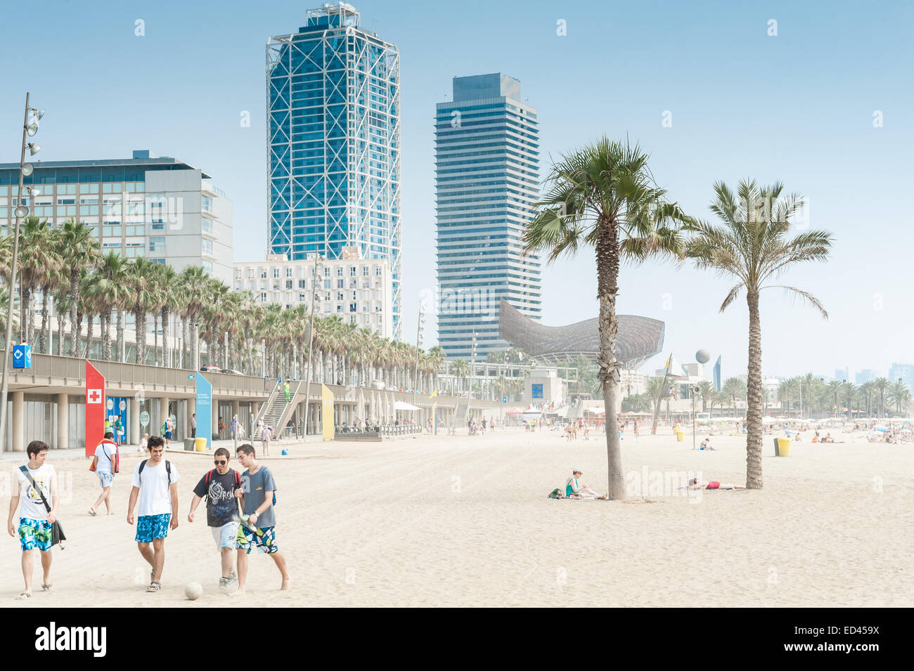 Young men kick a football on Barceloneta Beach, Barcelona, Catalonia ...