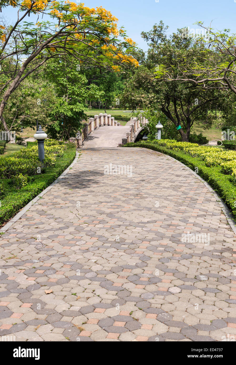 Brick pathway to the bridge in urban park Stock Photo - Alamy