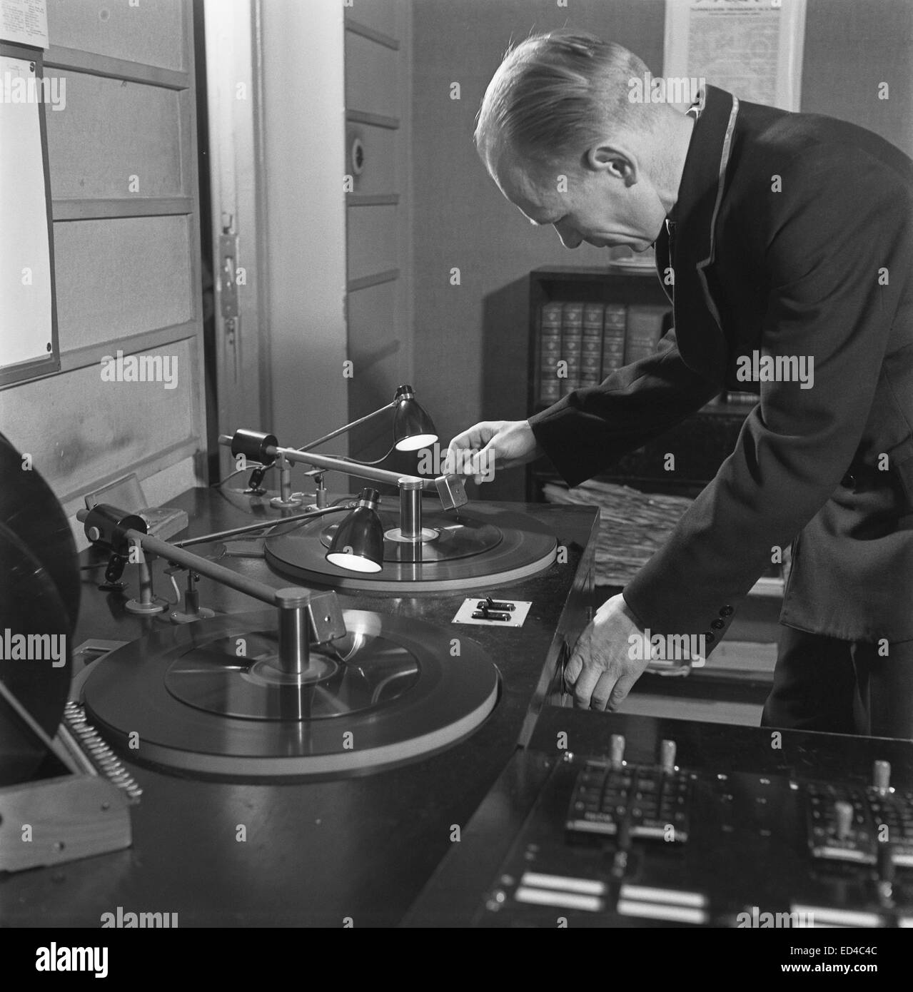 A 1940s-era radio broadcaster is seen transmitting records over the ...