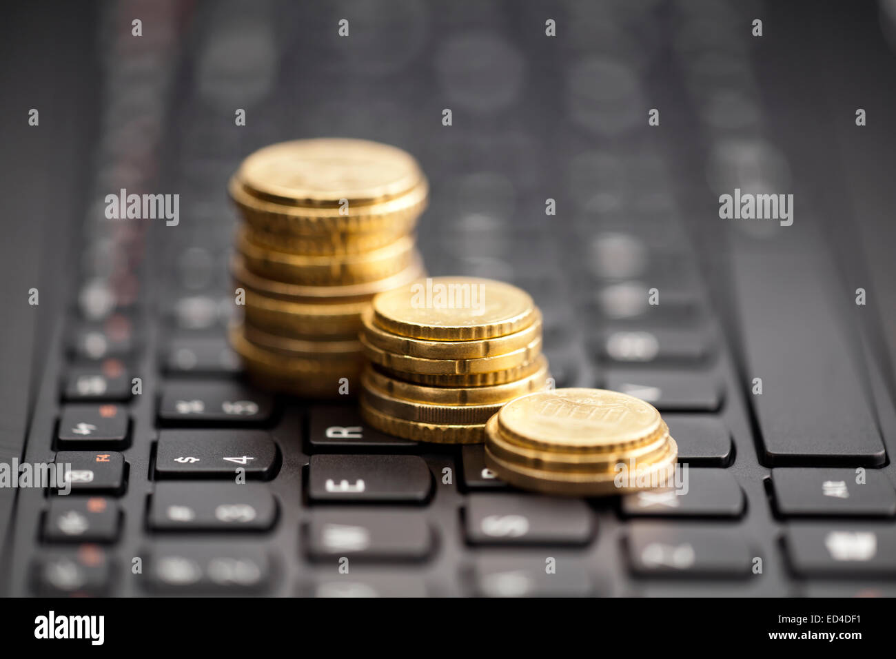 Rising coins on keyboard Stock Photo - Alamy