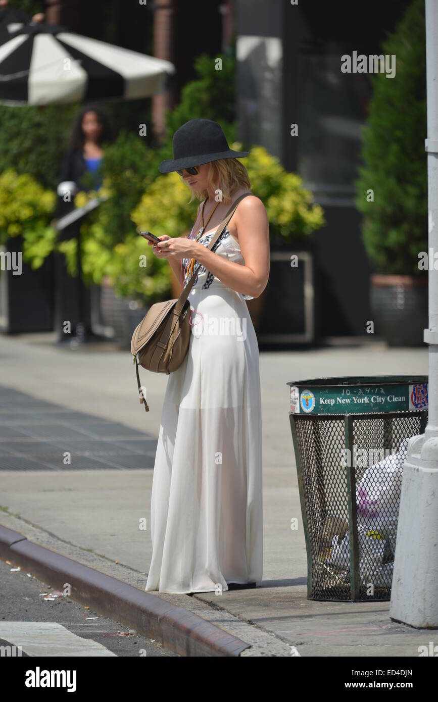 Beth Behrs walking in Soho in a long white dress complimented with a ...