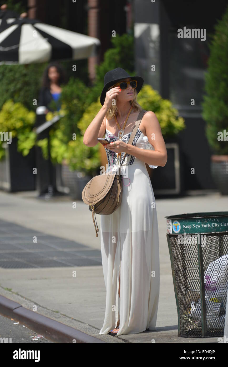 Beth Behrs walking in Soho in a long white dress complimented with a ...
