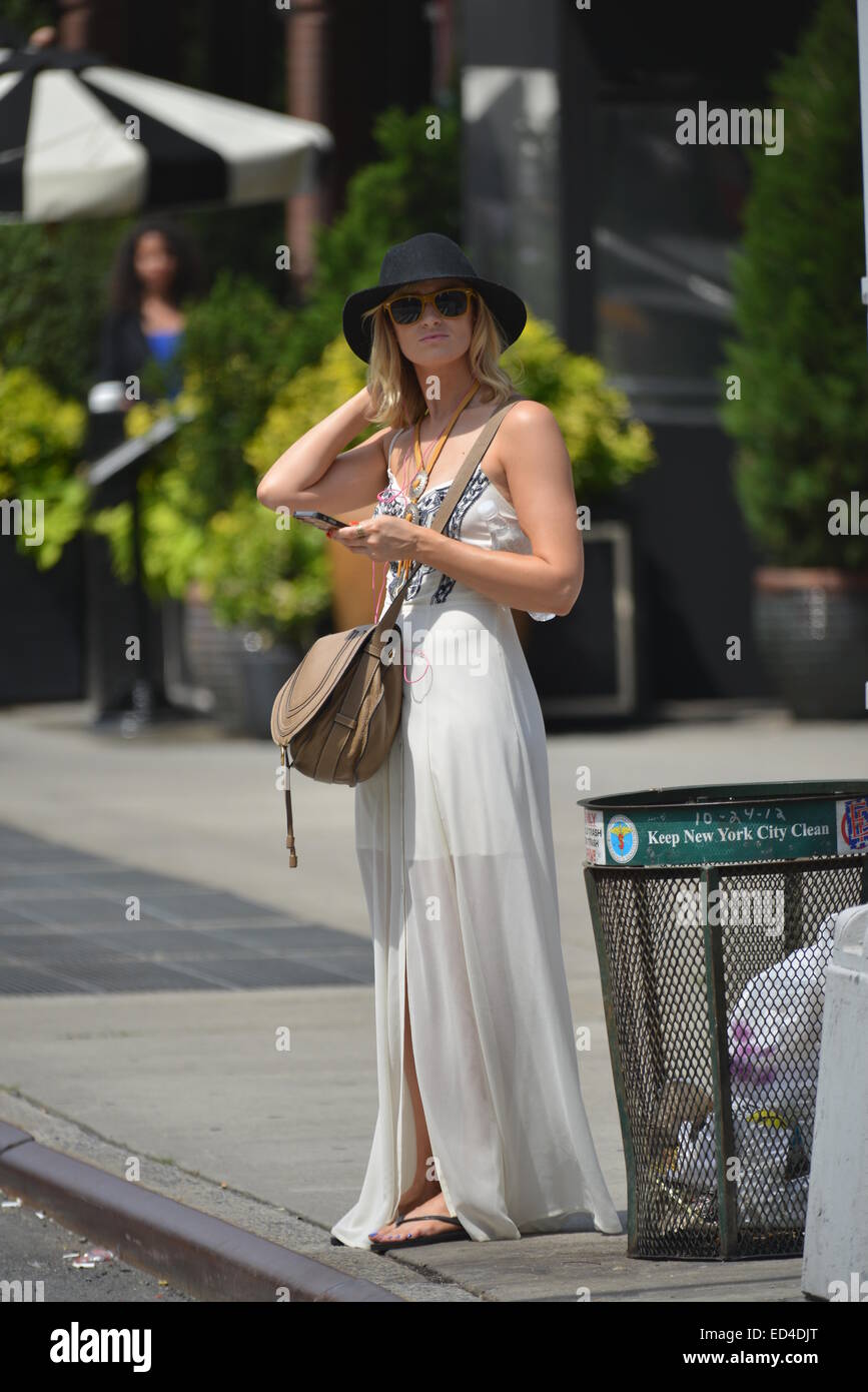 Beth Behrs walking in Soho in a long white dress complimented with a ...