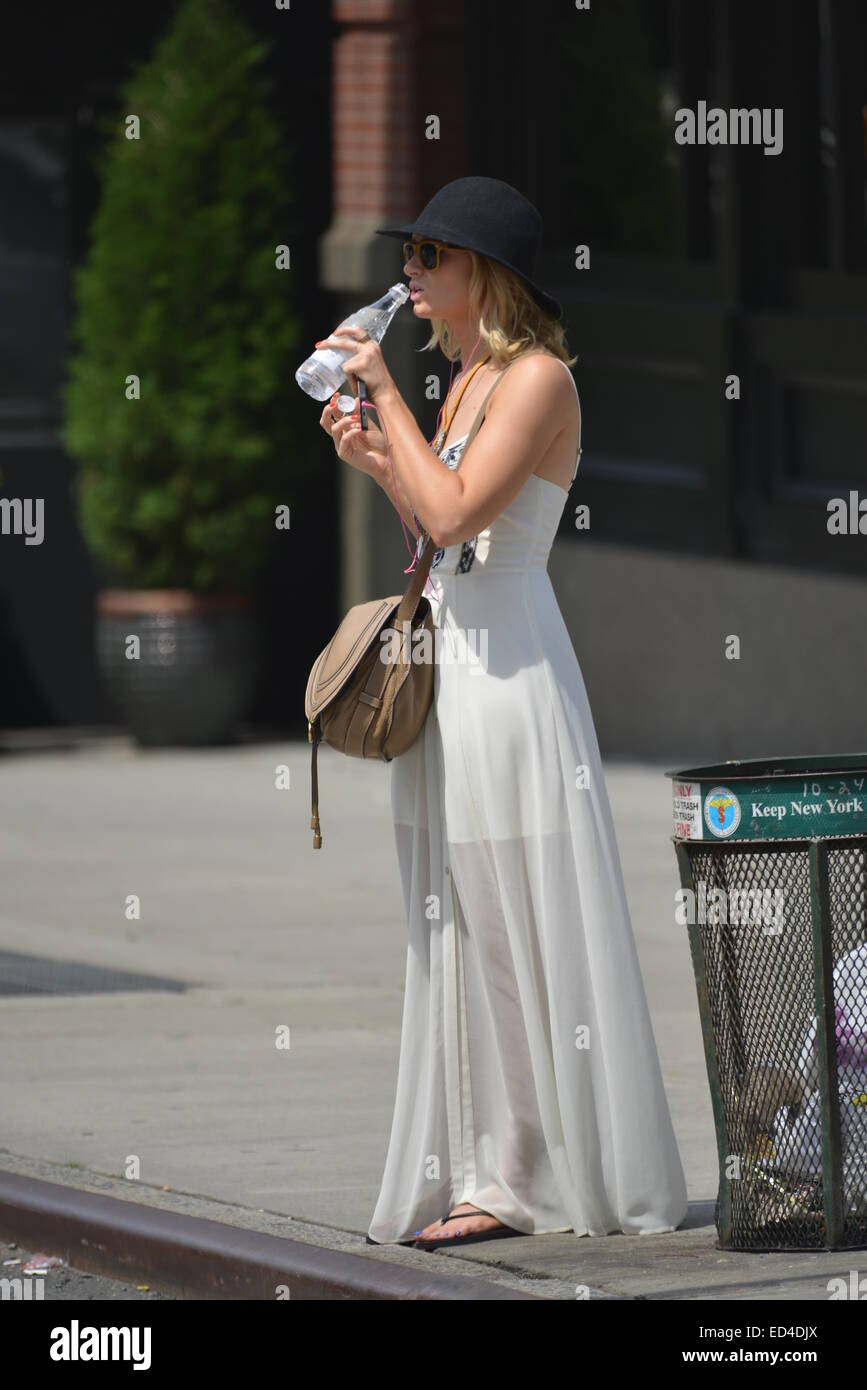 Beth Behrs walking in Soho in a long white dress complimented with a ...