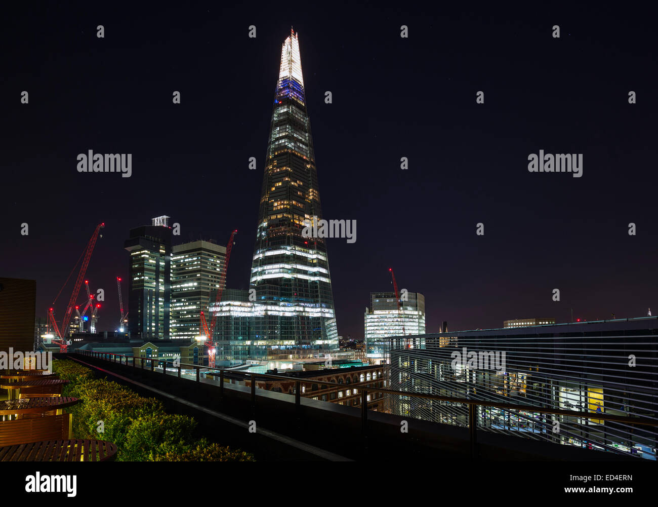 Night view of Shard building illuminated and towering over other ...