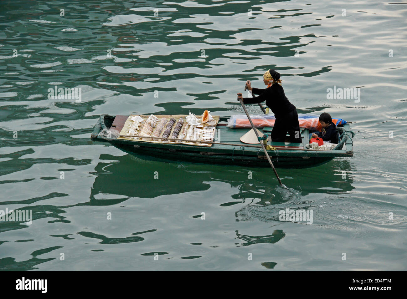 Watergoing vendor selling seashells to tourists, Halong Bay, Vietnam ...