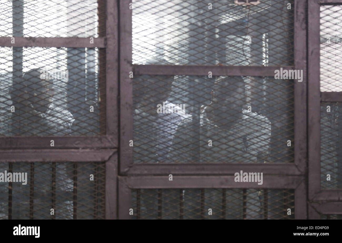 Cairo, Egypt. 25th Dec, 2014. Defendants stand in a courtroom cage ...
