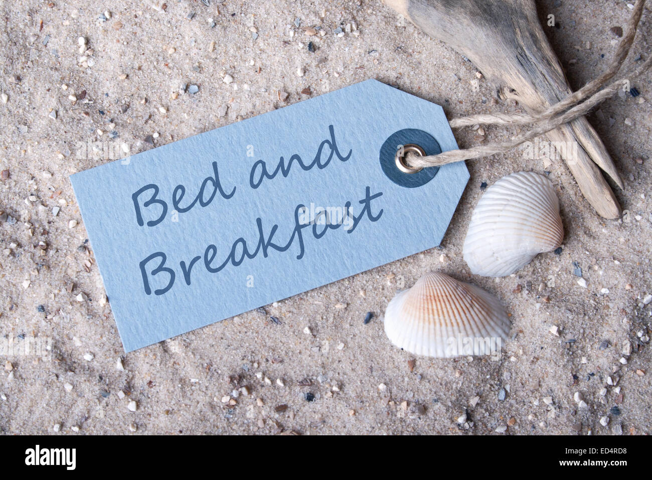 Sandy beach with shells and card with English text: Bed and Breakfast ...