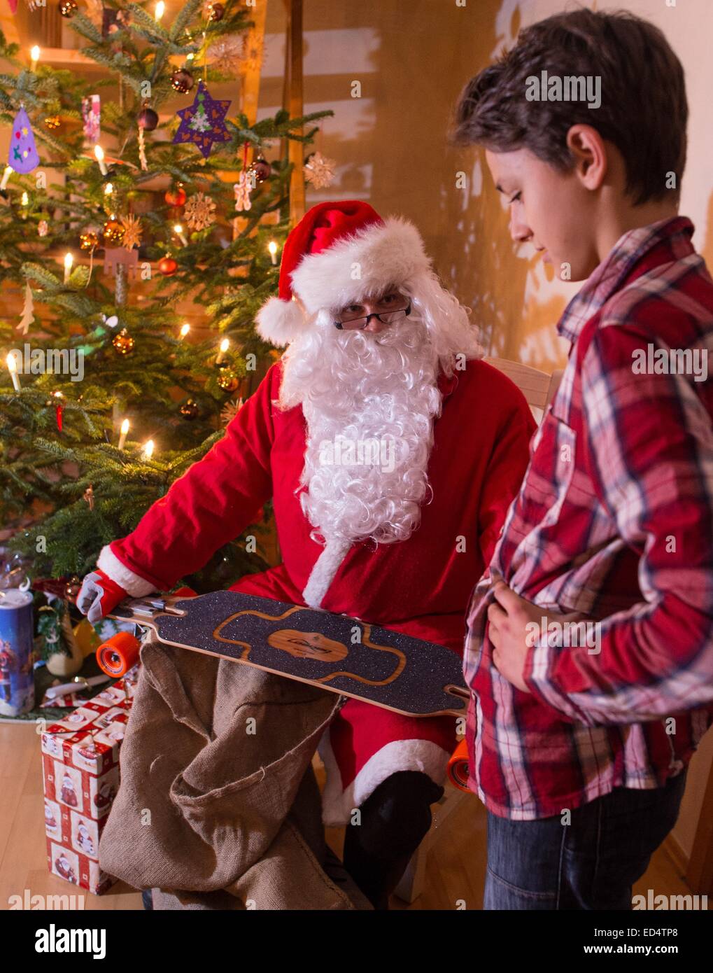 ILLUSTRATION - Santa Claus gives presents to a young boy standing next ...