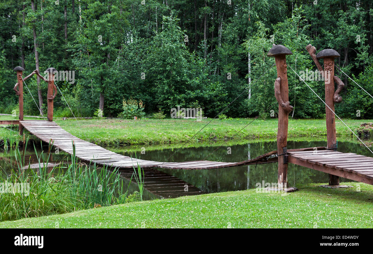 Wooden and funny bridge over little pond in park Stock Photo - Alamy