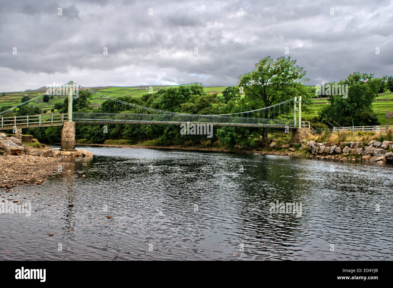 The swing bridge spanning the River Swale at reeth in Swaledale in the ...