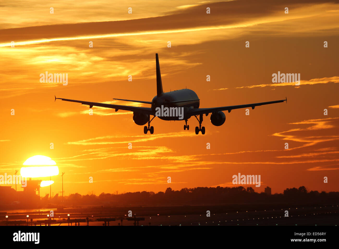 An airplane landing at an airport during sunset on vacation during a ...
