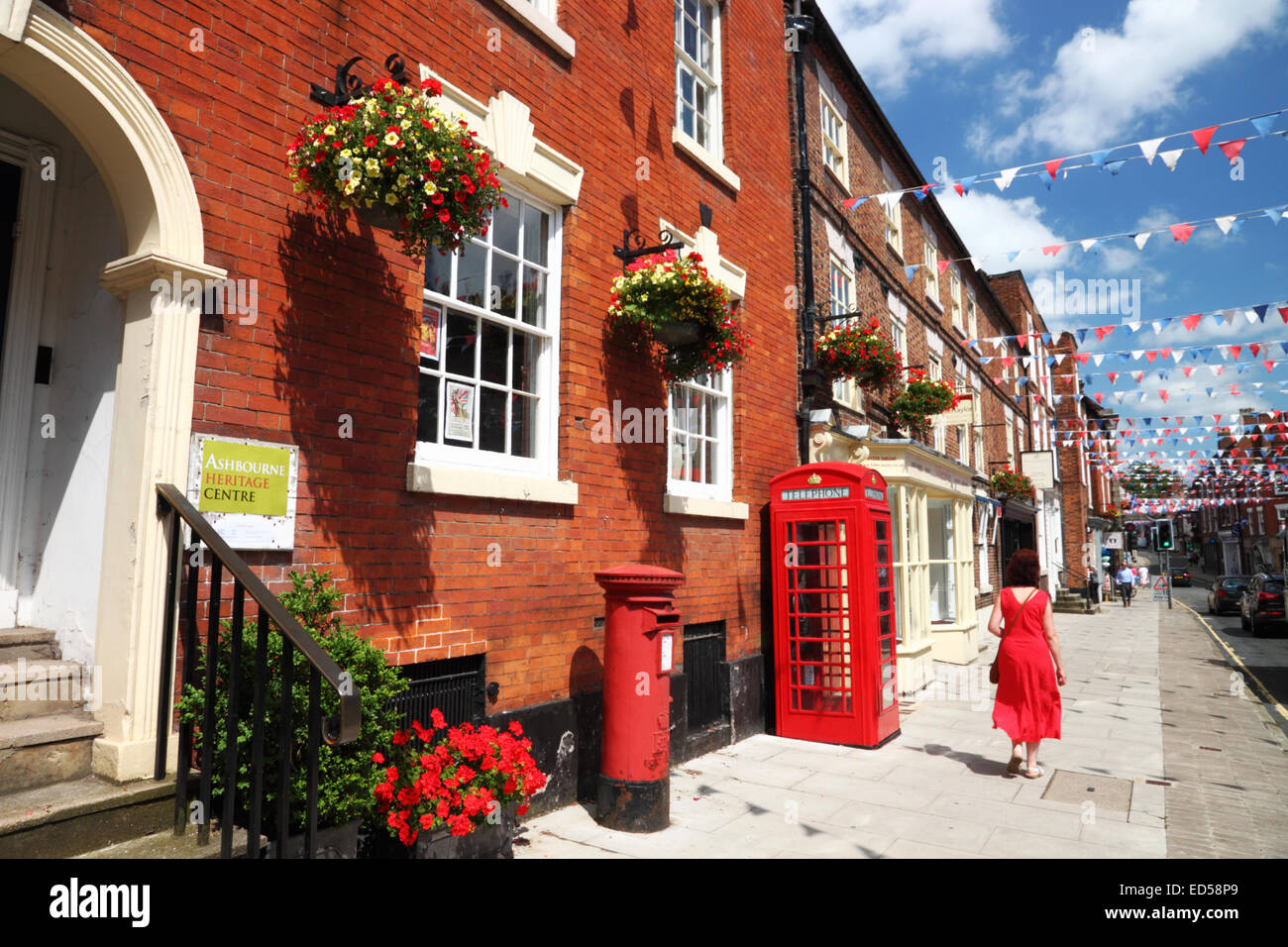 A street of an English town with red brick buildings, bunting, a red ...