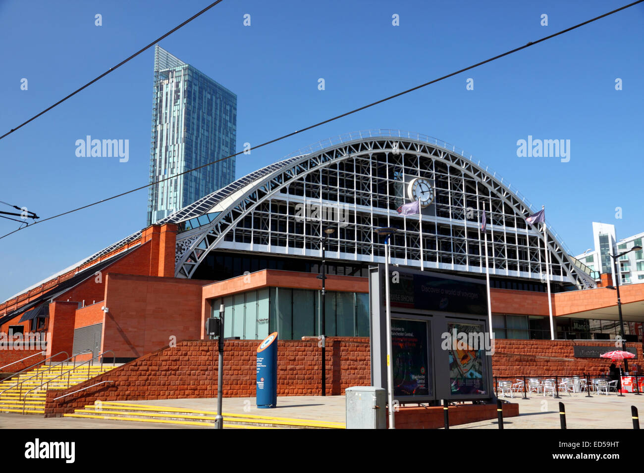An arched station building with overhead wires a modern tower block ...