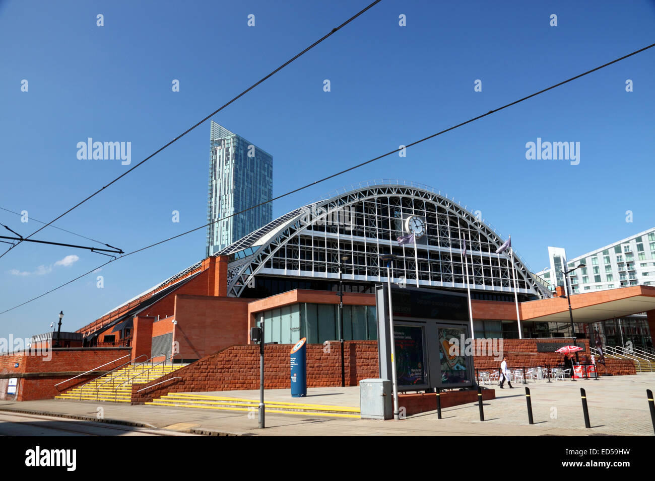 An arched station building with overhead wires a modern tower block ...