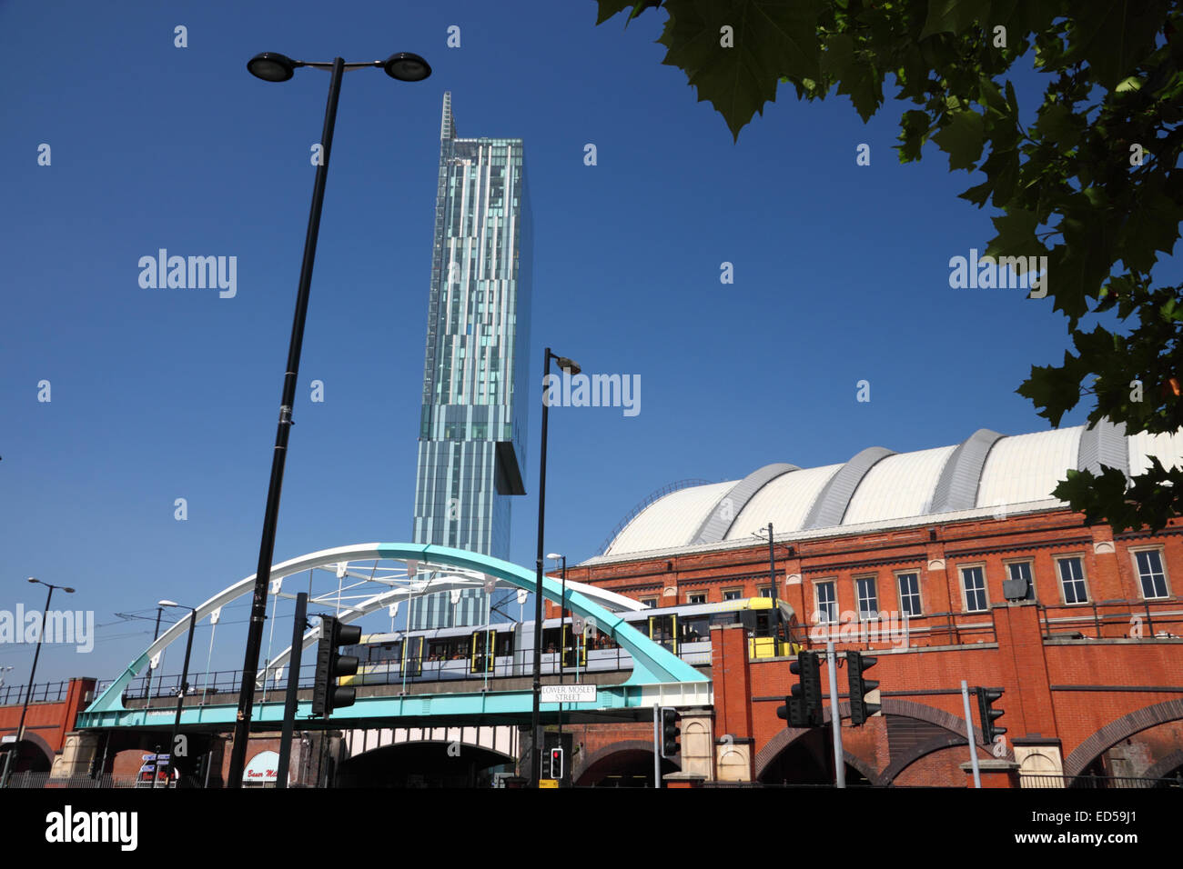 A yellow Metro Link tram crossing an iron bridge over Great Bridgewater ...