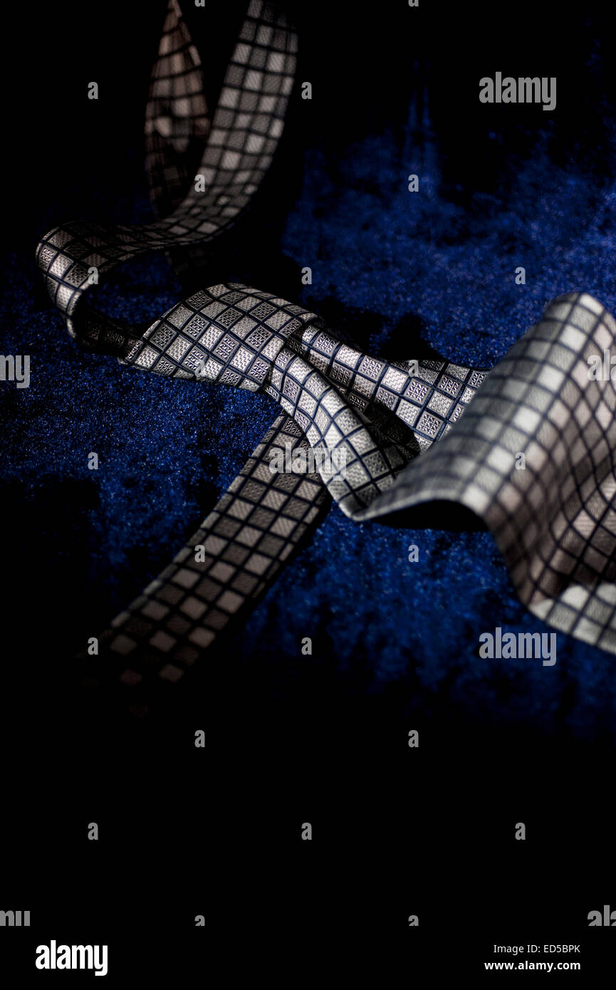 Gray necktie on a black background Stock Photo - Alamy