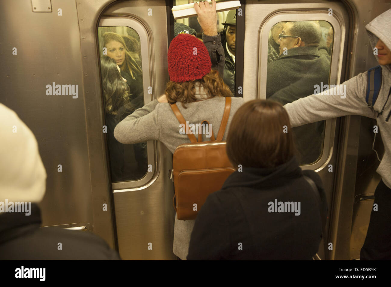 Woman tries to squeeze into a subway car when the doors were closing at ...