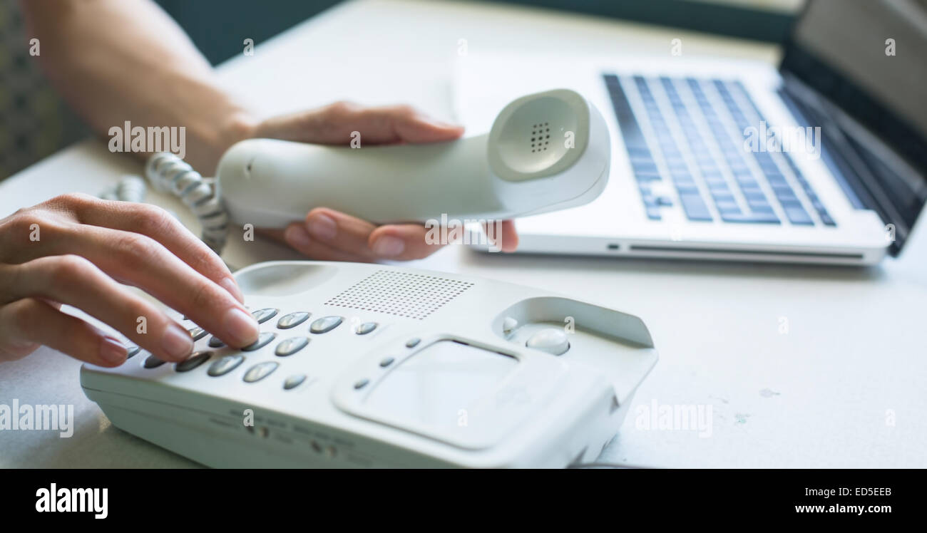Female hands using phone, laptop at background Stock Photo - Alamy