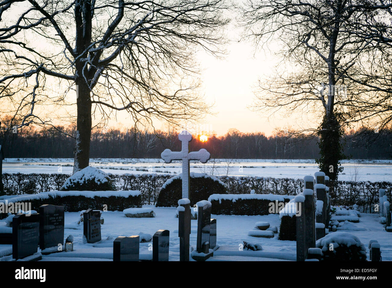 Graveyard in winter with sunset and snow Stock Photo - Alamy