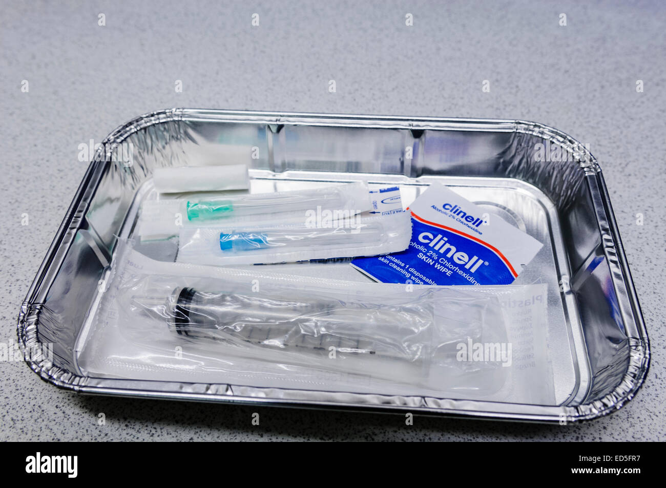 Aluminium tray filled with needles, syringe and other equipment ready ...