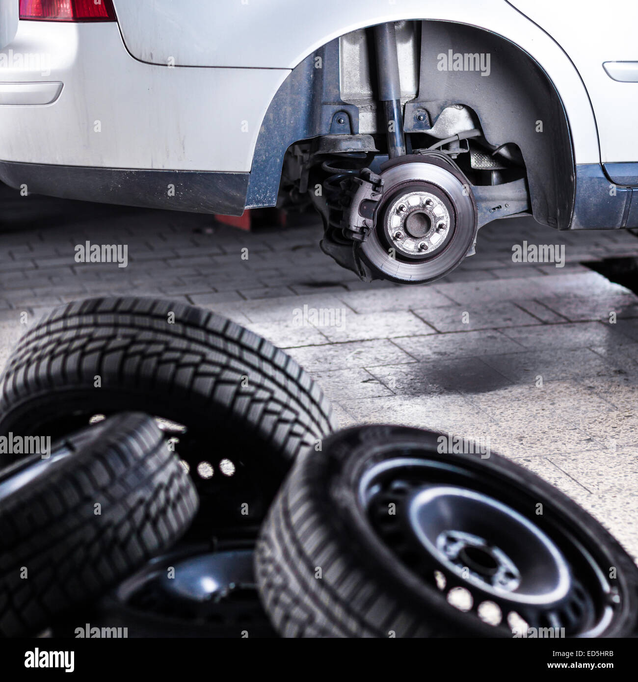 mechanic changing a wheel of a modern car (shallow DOF; color toned ...