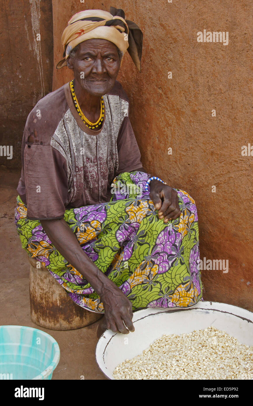 Woman cleaning corn kernels outside her mud hut, Gambaga, Ghana Stock ...