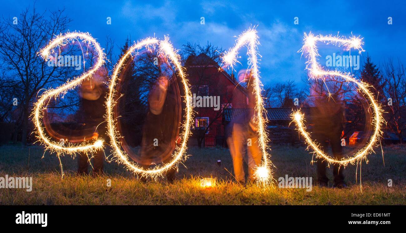 ILLUSTRATION - Four people write '2015' into the evening sky using ...