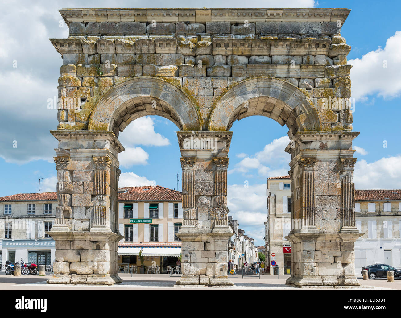 Arch of Saintes in France with houses, streets and white clouds in the ...