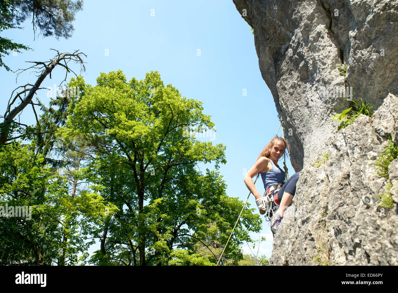 smiling young woman climbing a rock wall Stock Photo - Alamy