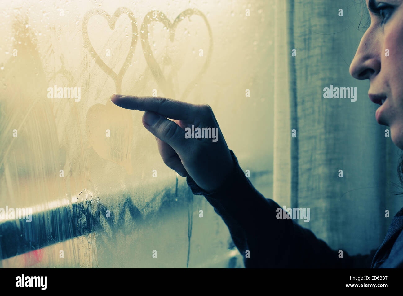 woman drawing heart on wet window Stock Photo - Alamy