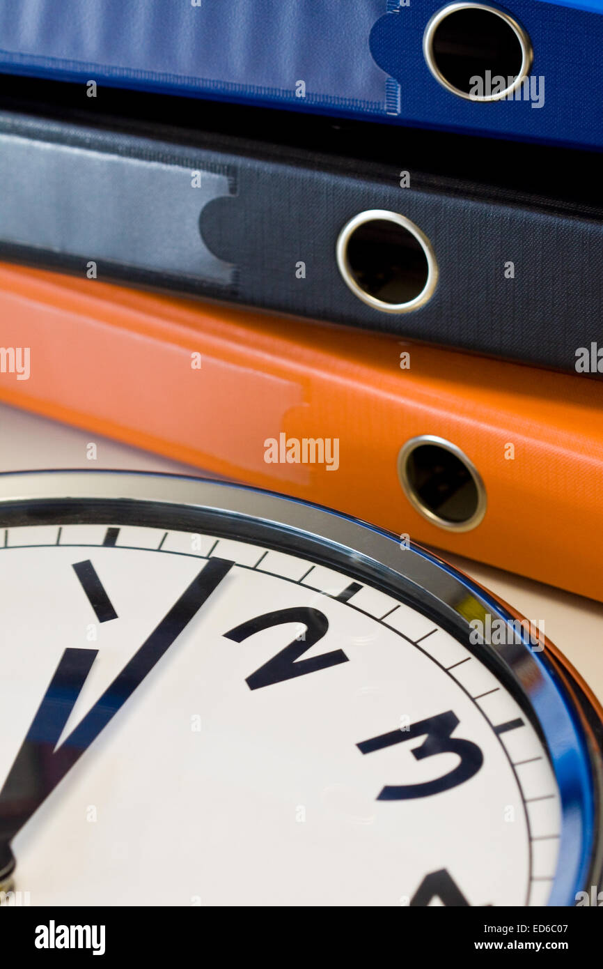 The clock in a table near colored binders in office, workplace Stock ...