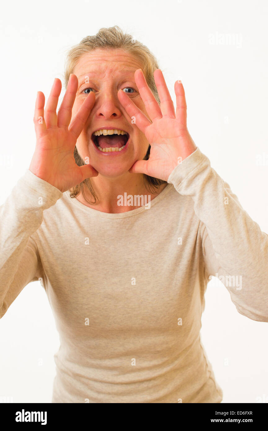 A forty year old caucasian woman shouting yelling through her cupped ...
