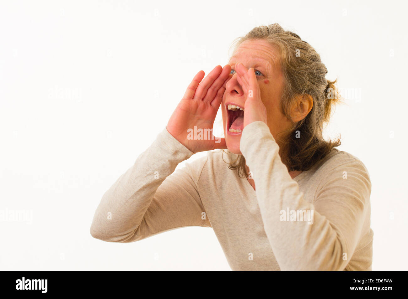 A forty year old caucasian woman shouting yelling through her cupped ...