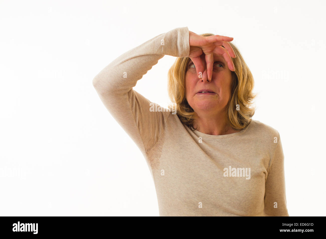 A forty year old caucasian woman holding pinching her nose - bad smell ...