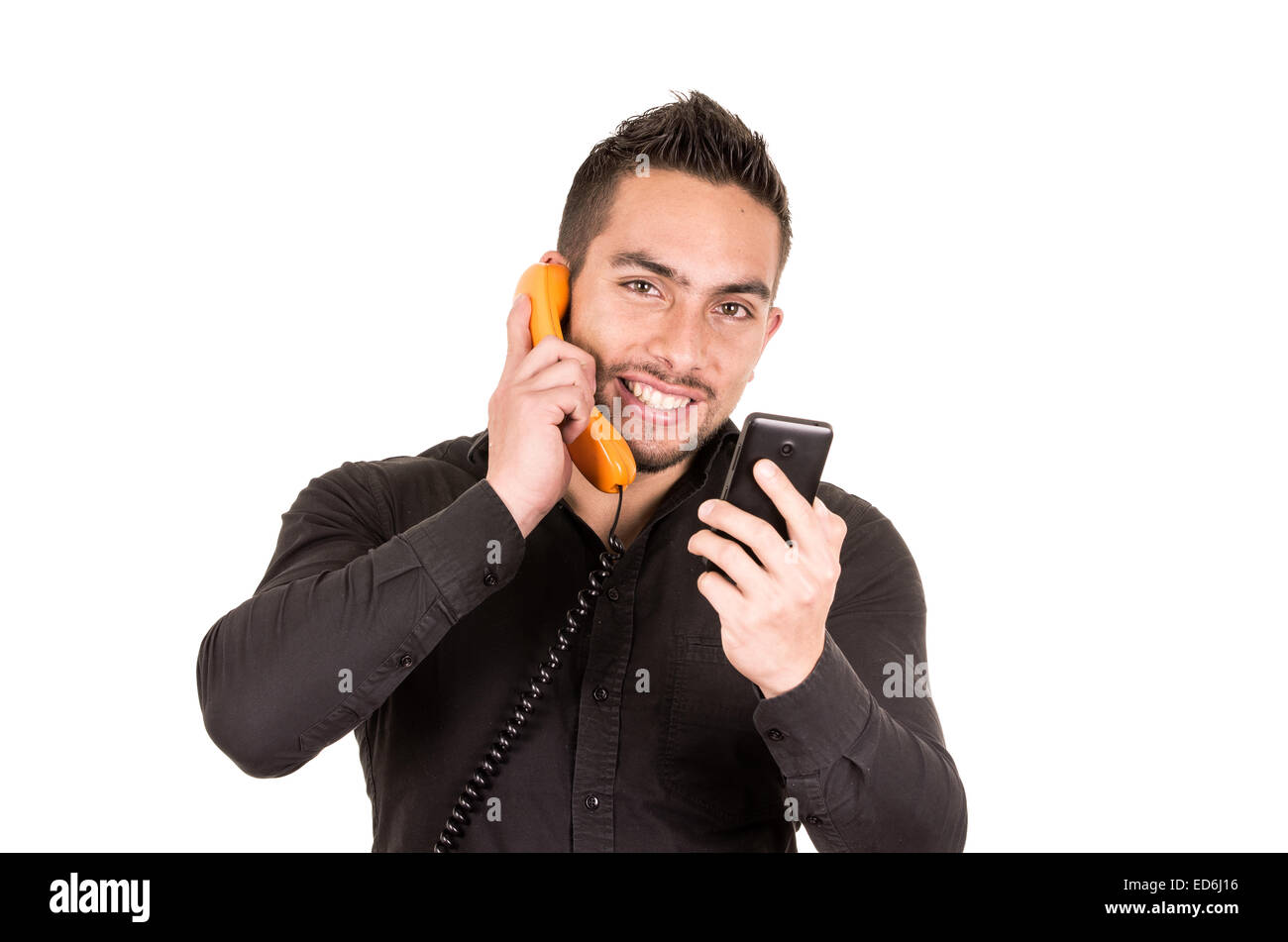 closeup shot of handsome man using corded telephone and cell phone ...