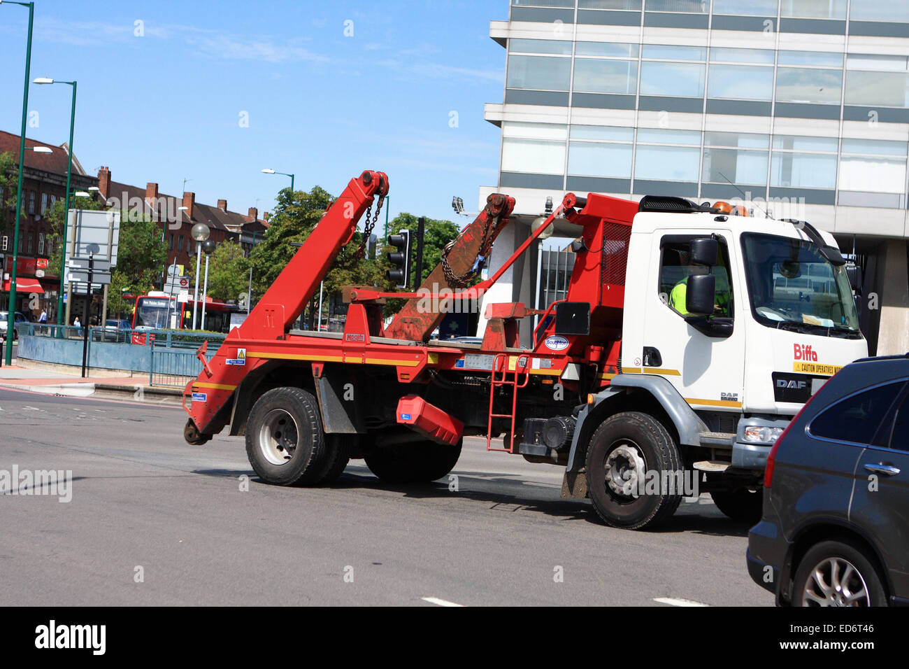 An empty skip loader truck traveling around a roundabout at Tolworth ...