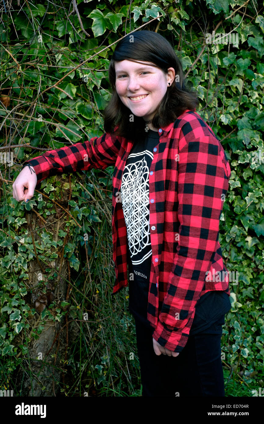 twelve year old smiling girl posing for a portrait in family garden ...