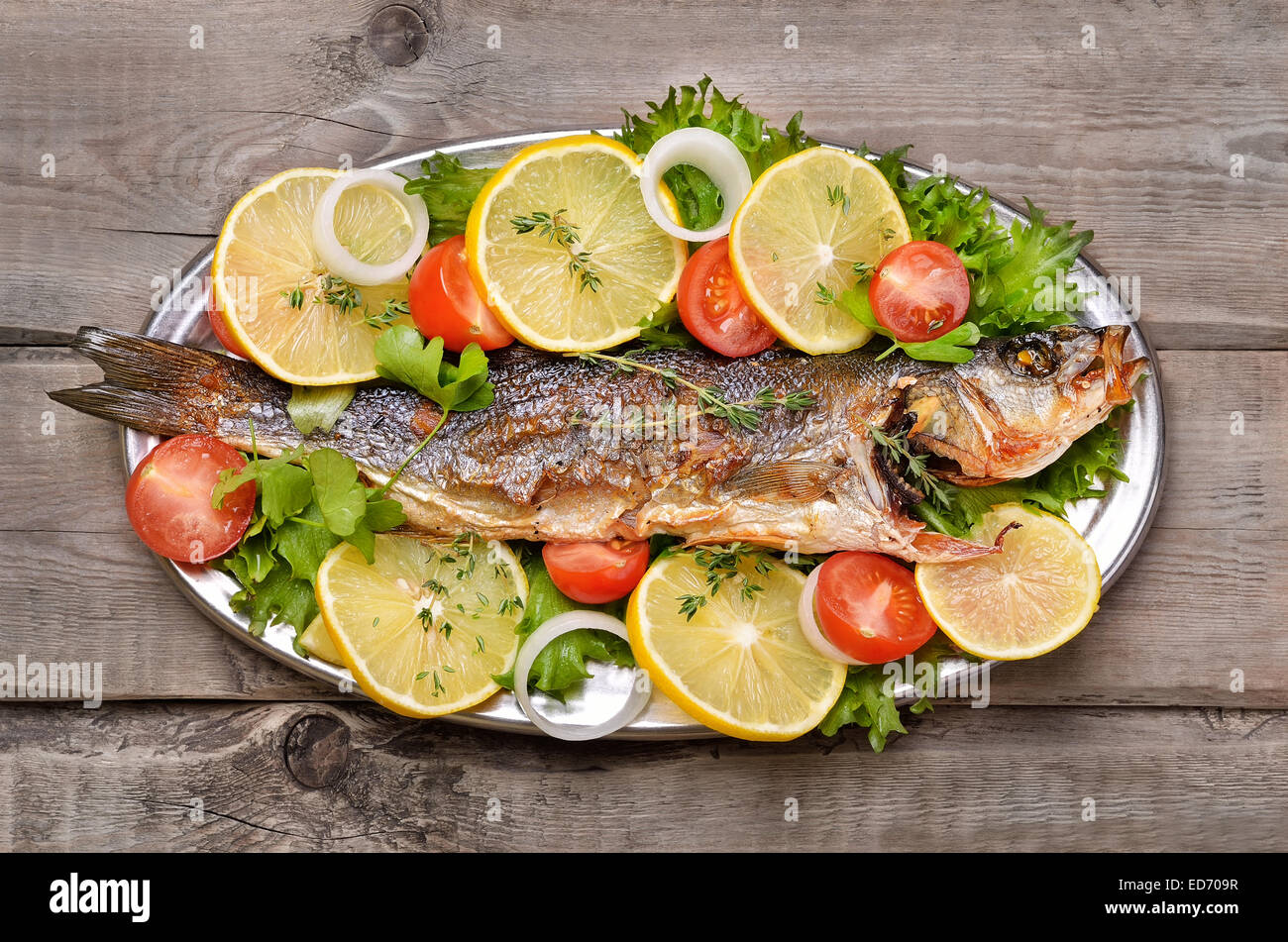 Grilled fish with vegetable on wooden table Stock Photo - Alamy