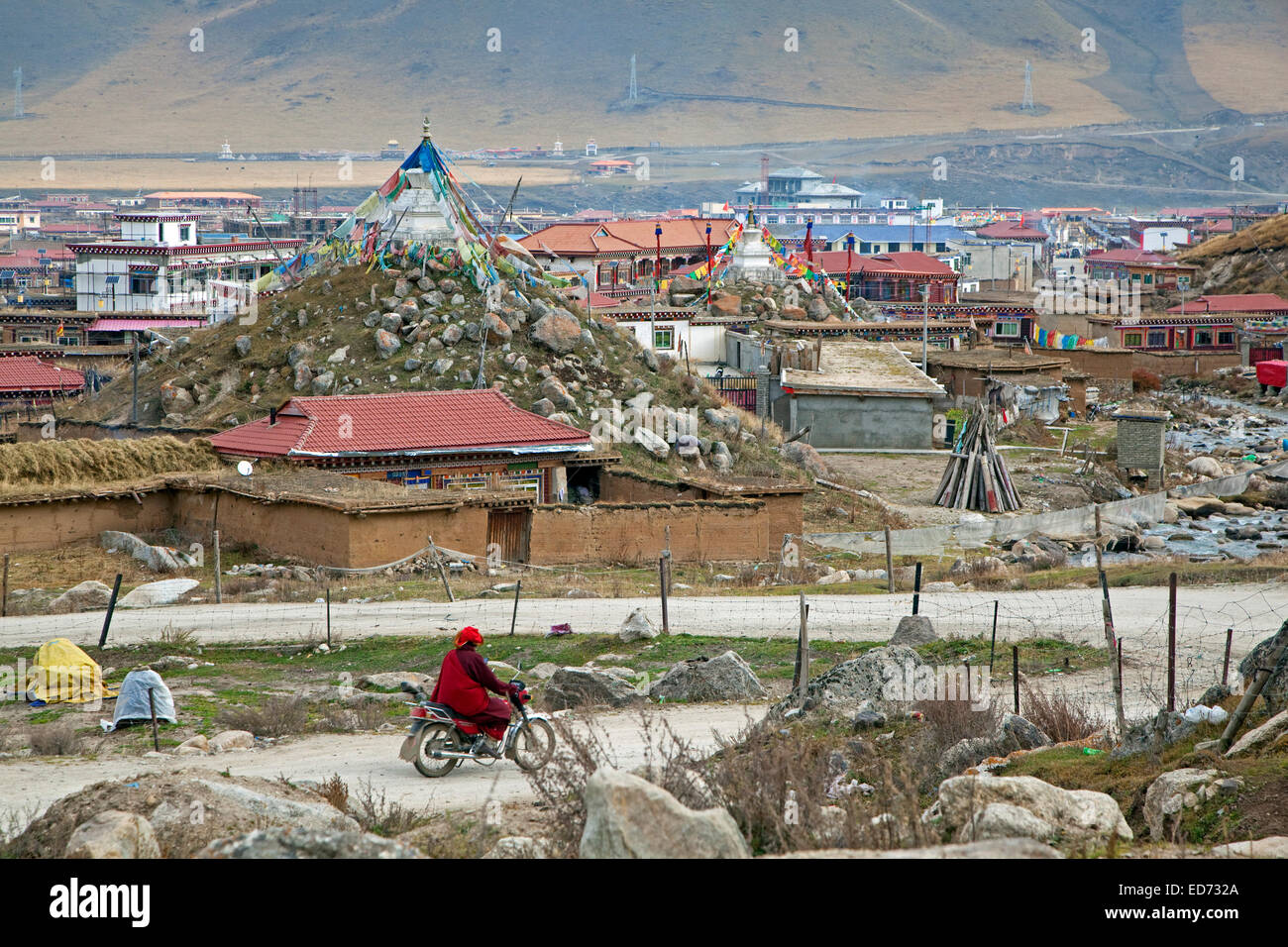 Tibetan monk riding motorbike to the village Zhuqing, Sichuan Province ...